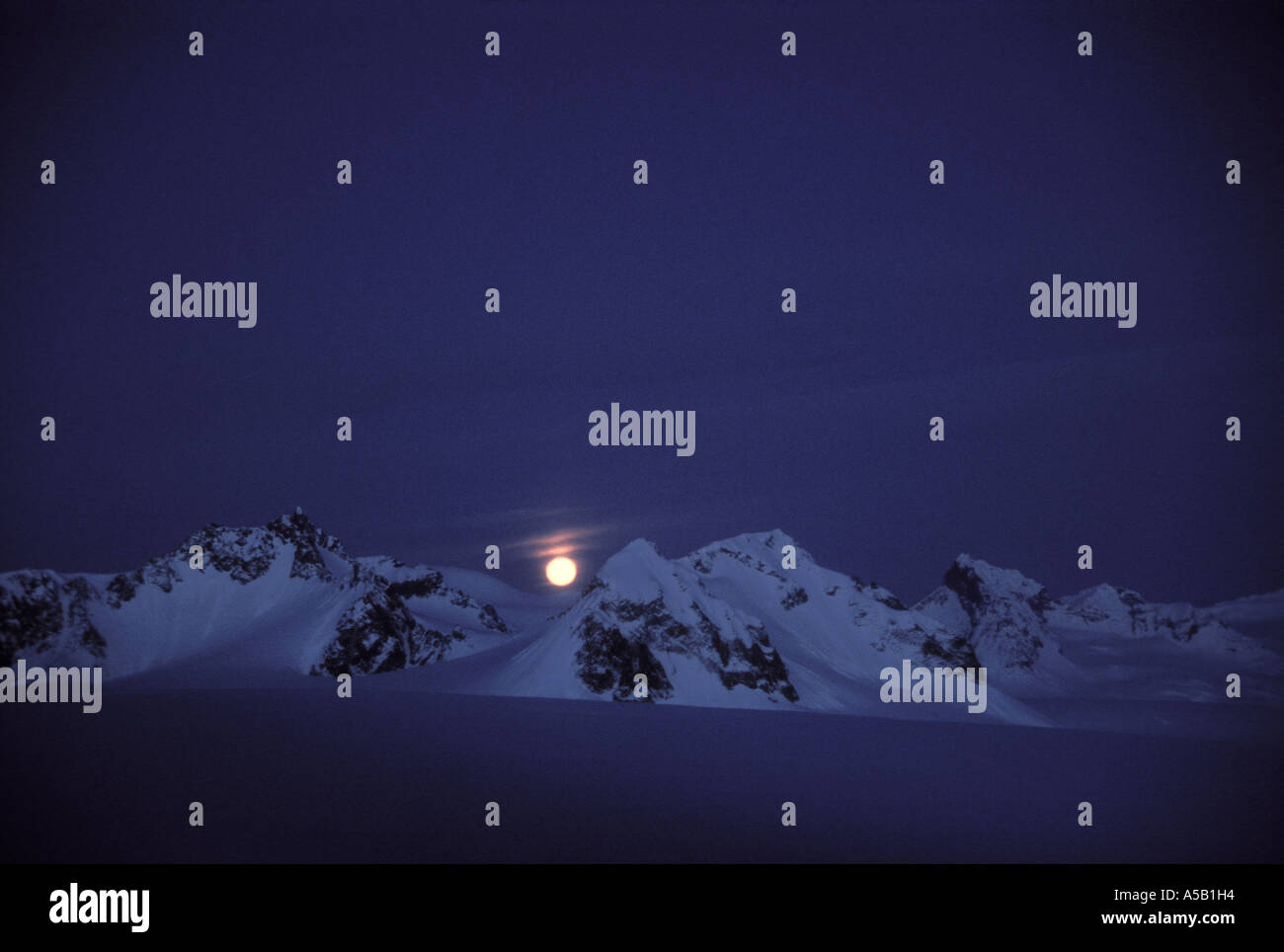 Full moon over snow covered mountains and glacier Mount Douglas volcano ...
