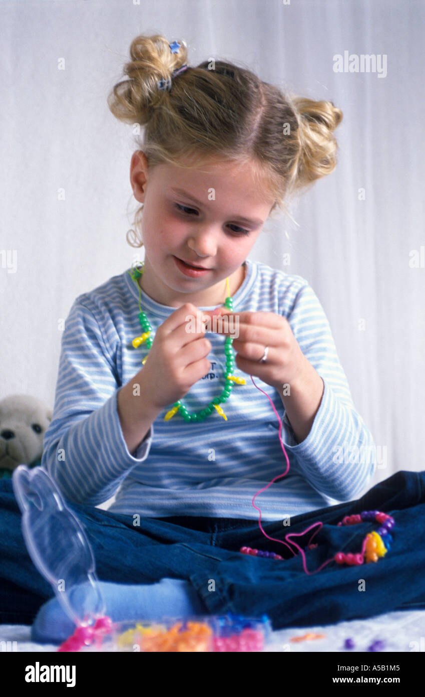 Child stringing beads hi-res stock photography and images - Alamy