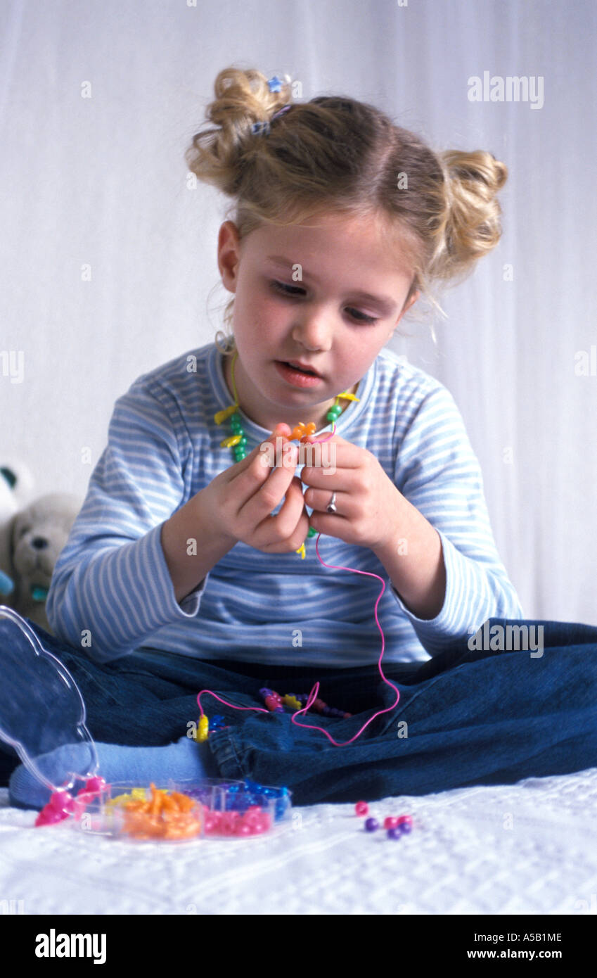 Child stringing beads hi-res stock photography and images - Alamy