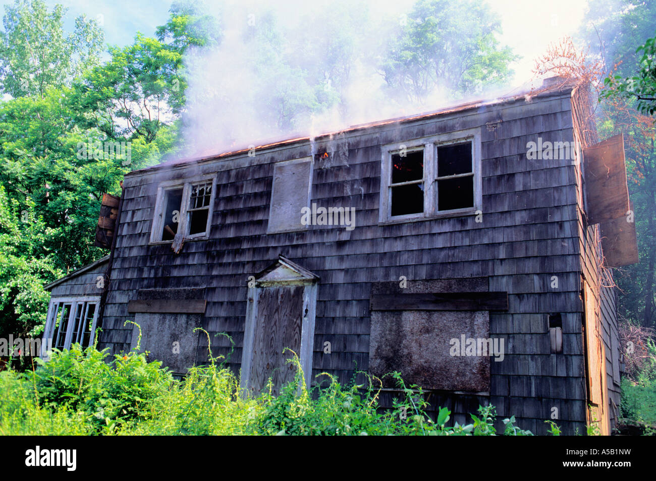 Rural secluded isolated wood frame house on fire in the country. Smoke ...