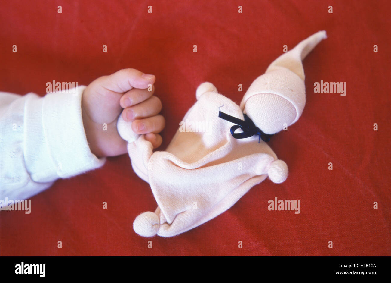 Baby hand with a soft pink baby doll Stock Photo - Alamy