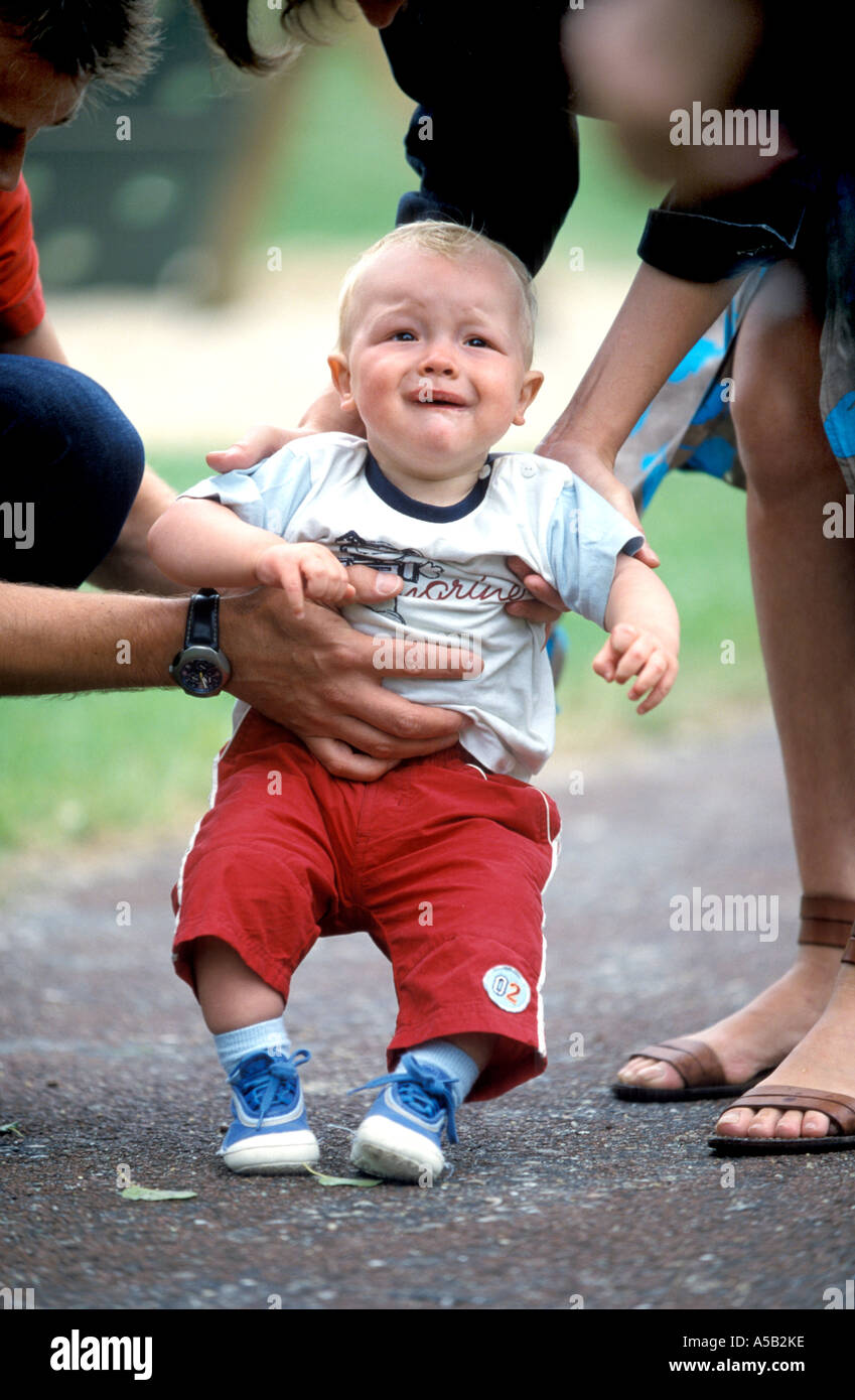 Fallen baby is lifted by parents Stock Photo - Alamy