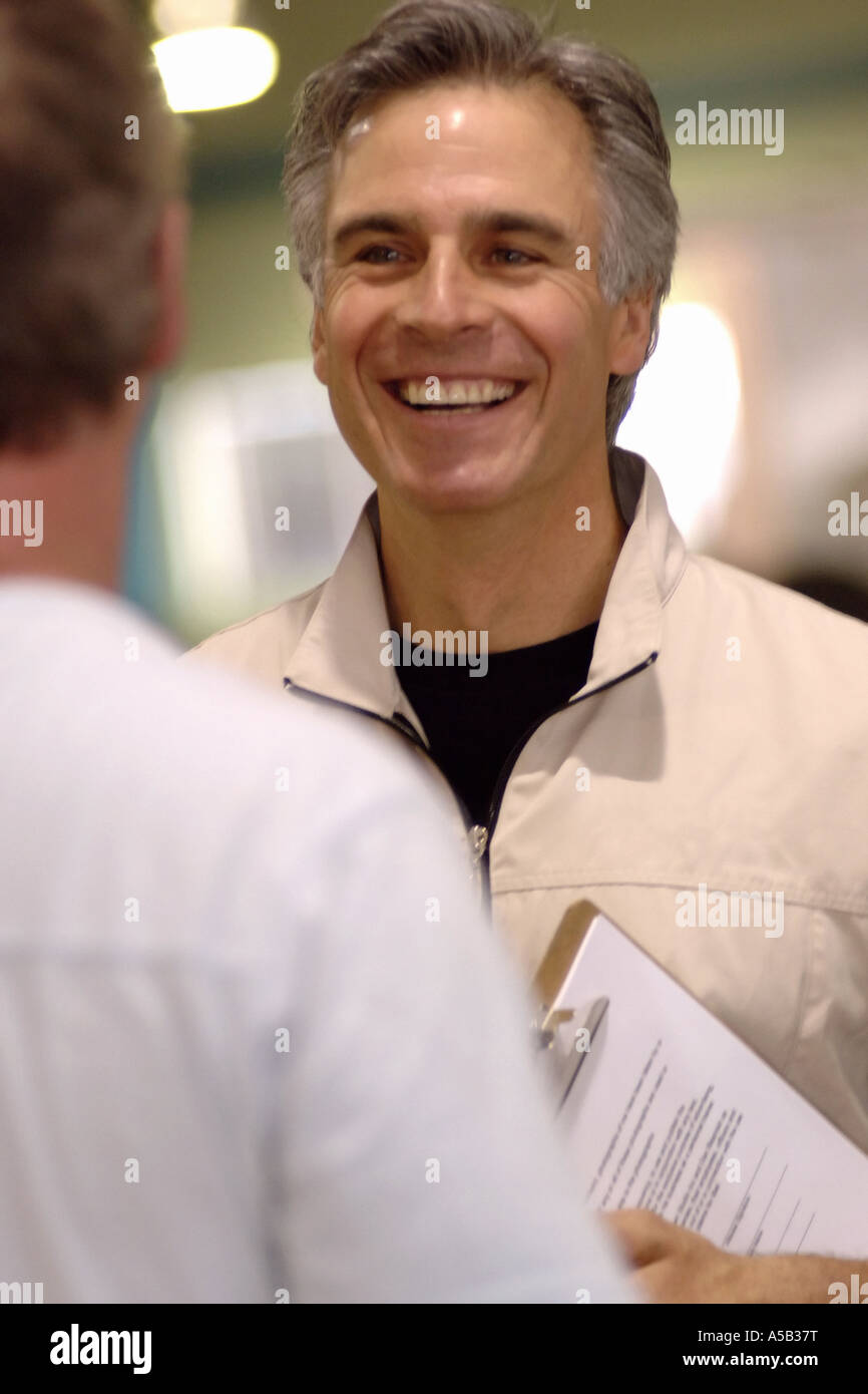 Friendly man speaking to another Stock Photo - Alamy