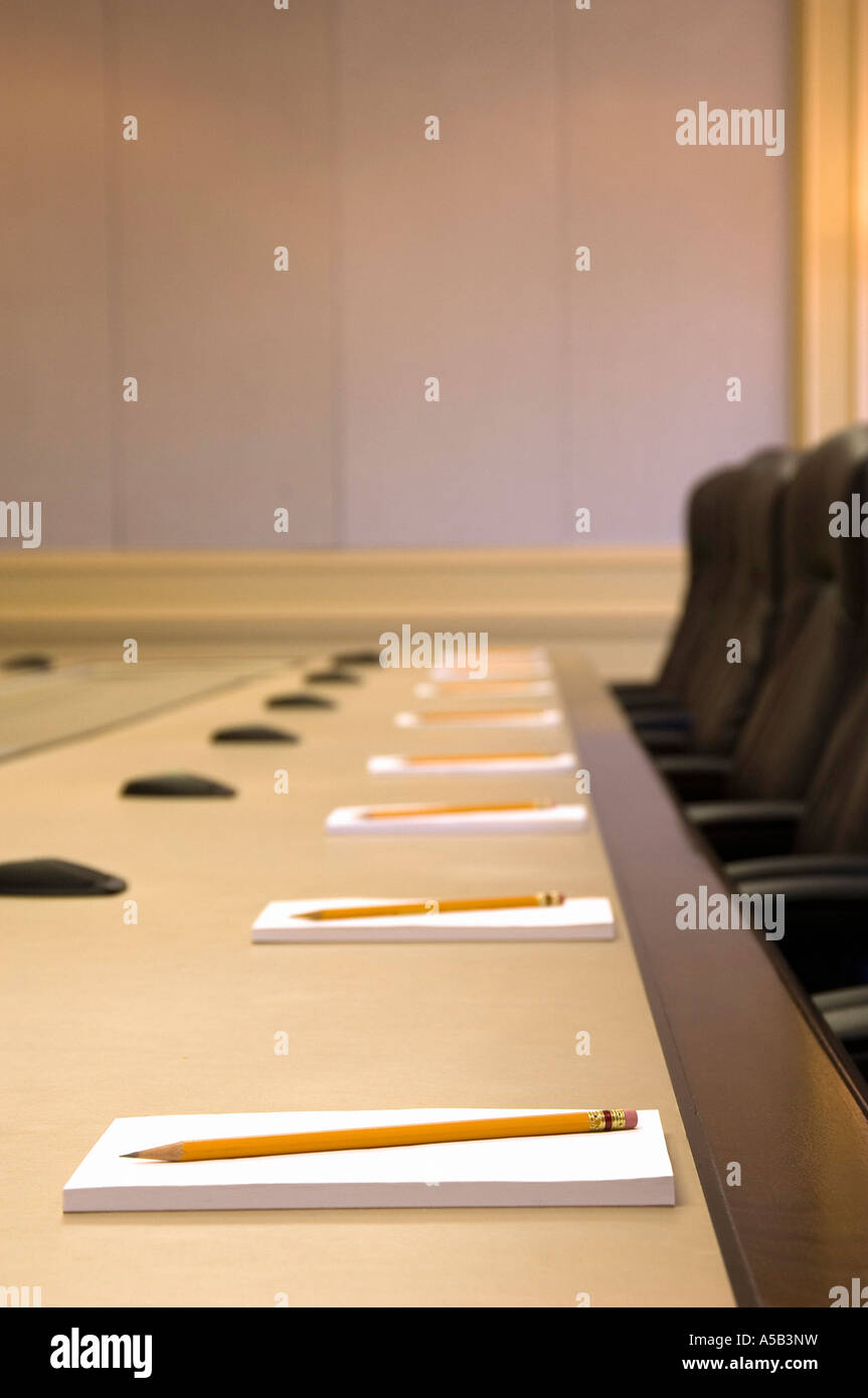 Pencils and notepads lined up on boardroom table Stock Photo - Alamy