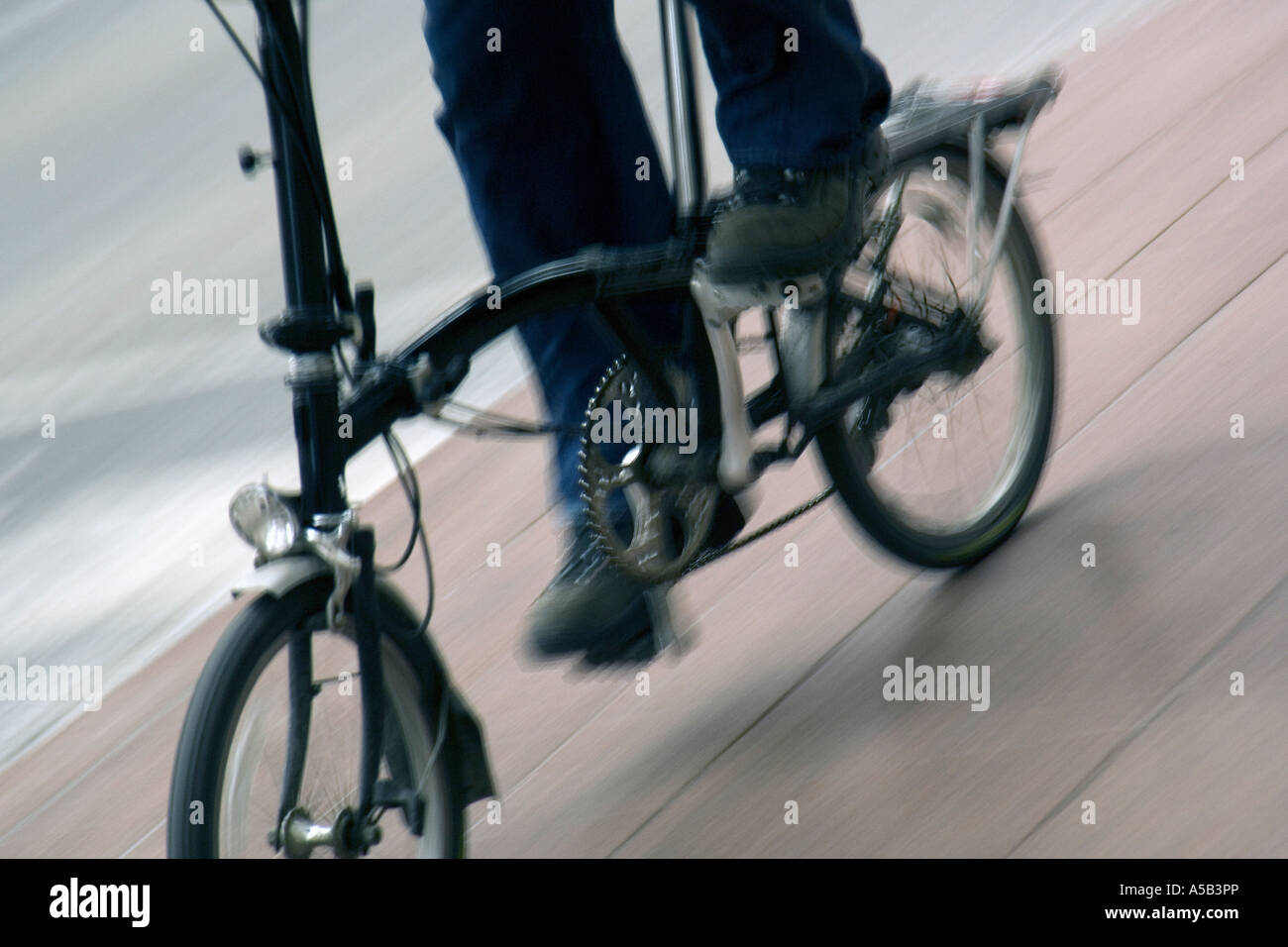 Person riding folding bicycle Stock Photo - Alamy
