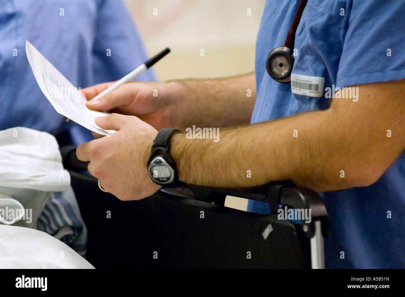 Physician writing notes while treating patient Stock Photo - Alamy