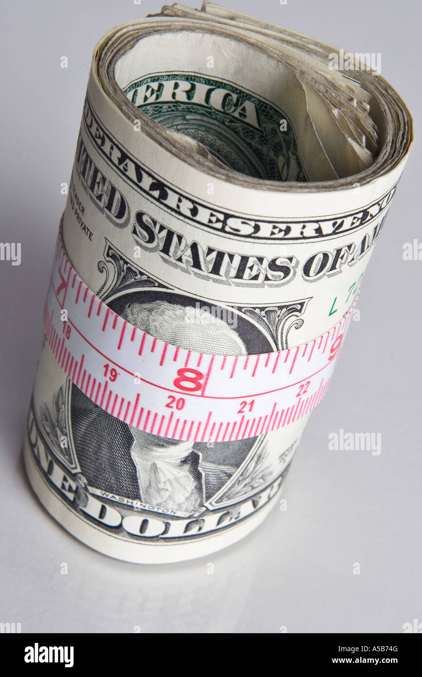 Roll of dollars wrapped with a tape measure Stock Photo - Alamy