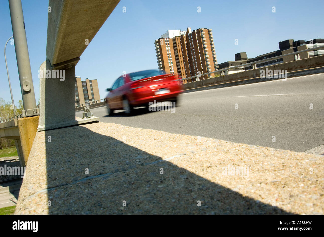 Red car driving over freeway overpass Stock Photo - Alamy