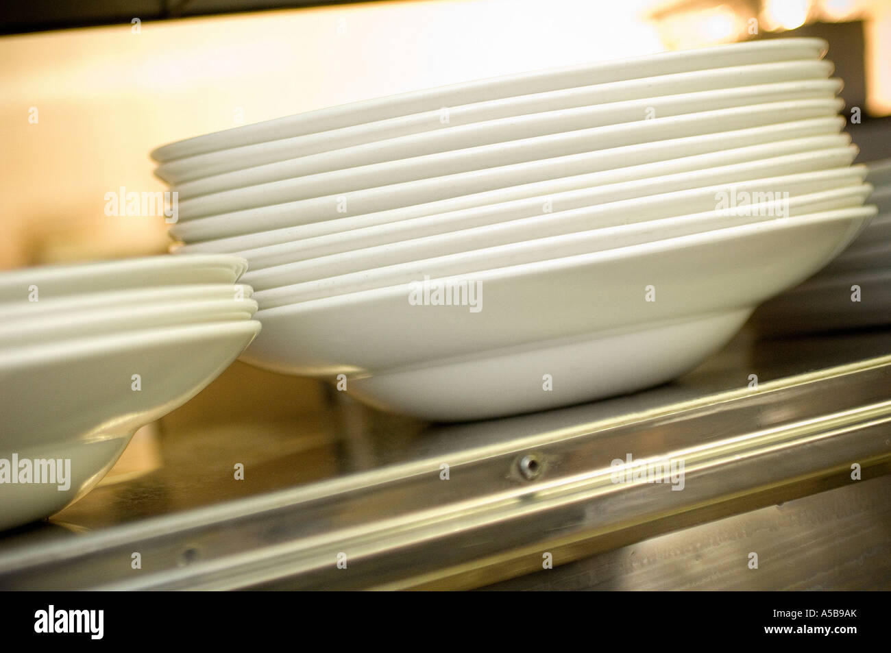 Stacked dinner plates ready in restaurant kitchen Stock Photo - Alamy