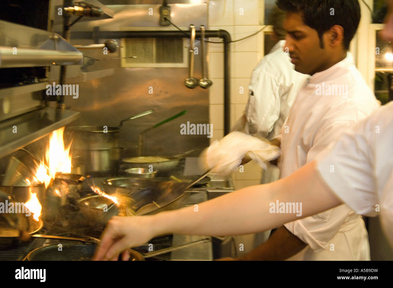 Team of restaurant kitchen staff busy at work Stock Photo - Alamy