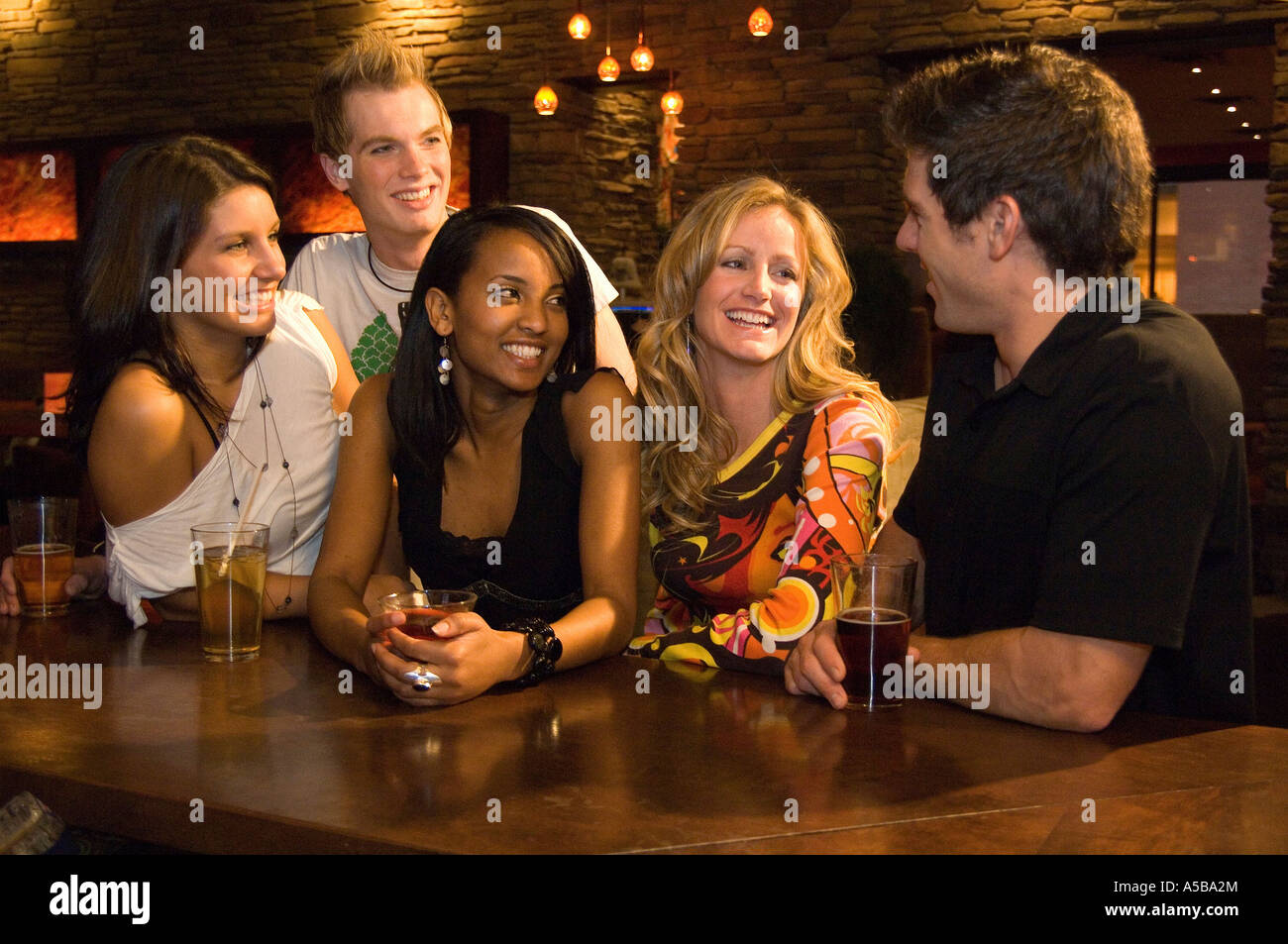 Party of five friends socializing at the pub Stock Photo - Alamy