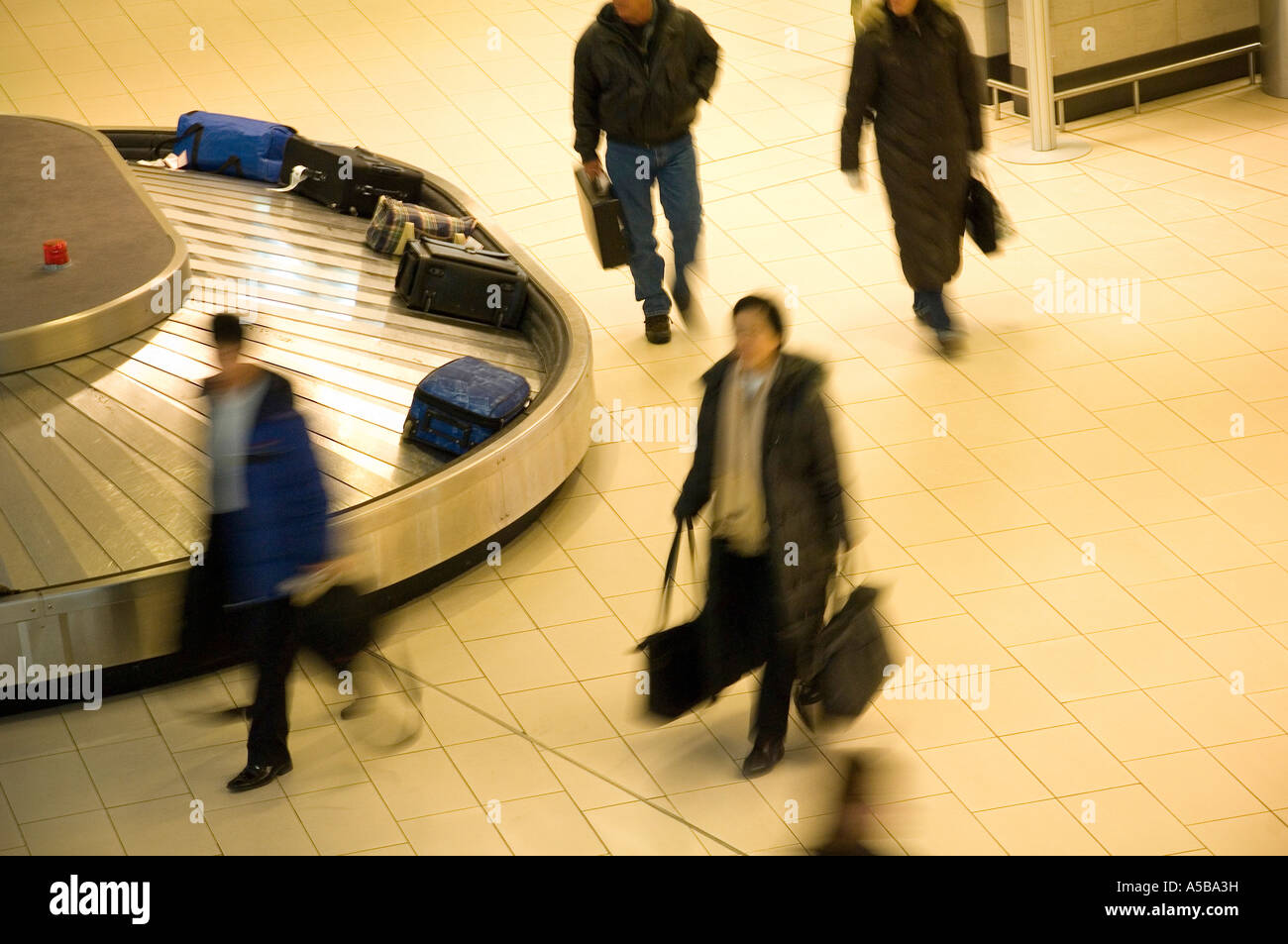 Travelers collecting luggage from airport baggage carousel Stock Photo ...