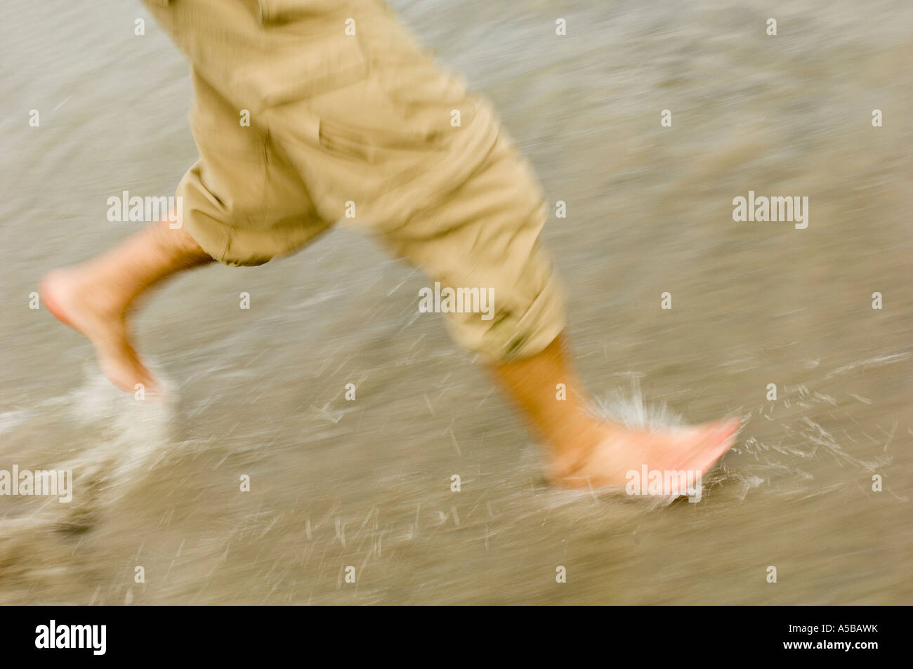 Running feet through water at the beach Stock Photo - Alamy
