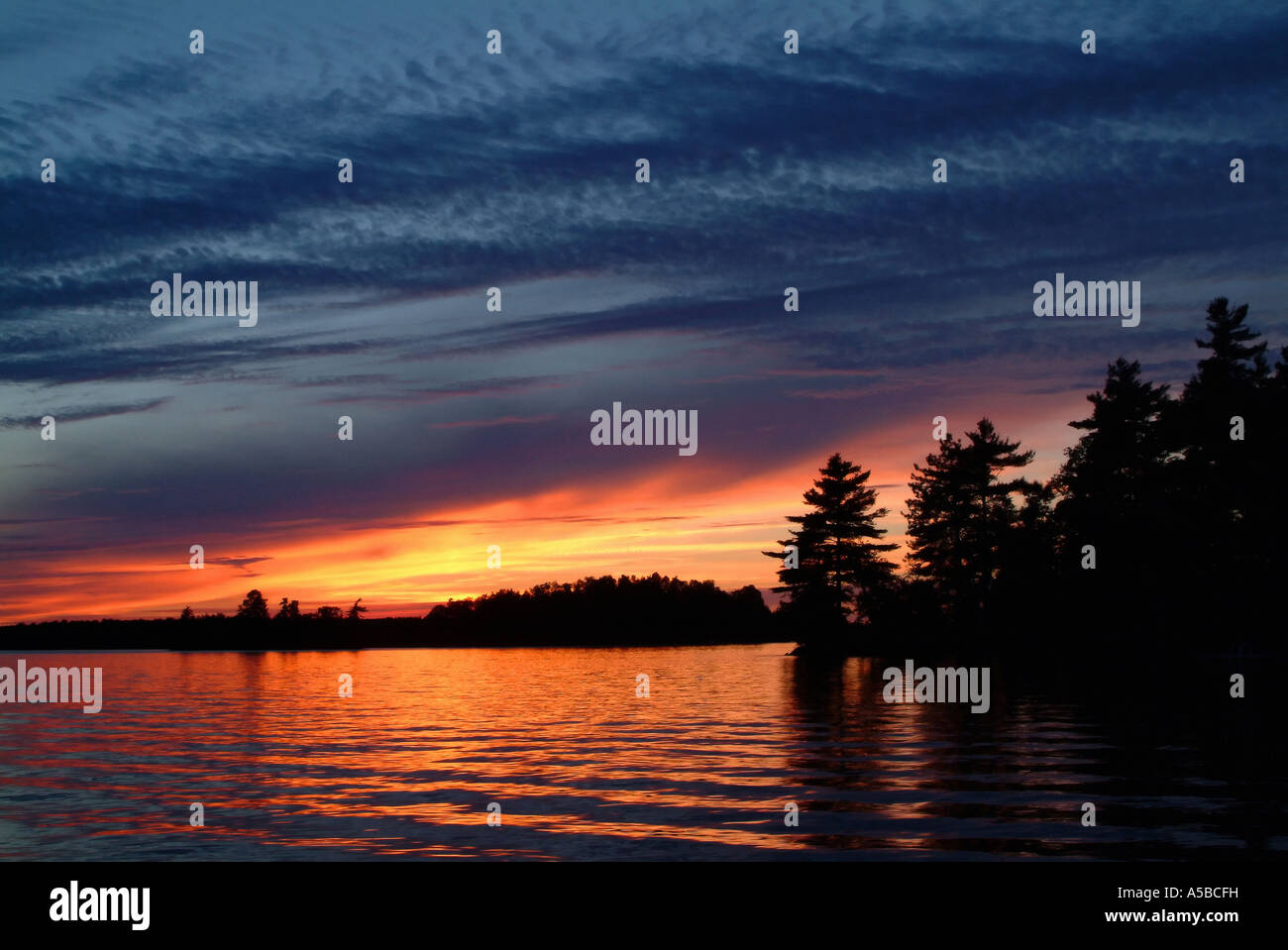 Canadian summer sunset reflecting in a lake Stock Photo - Alamy