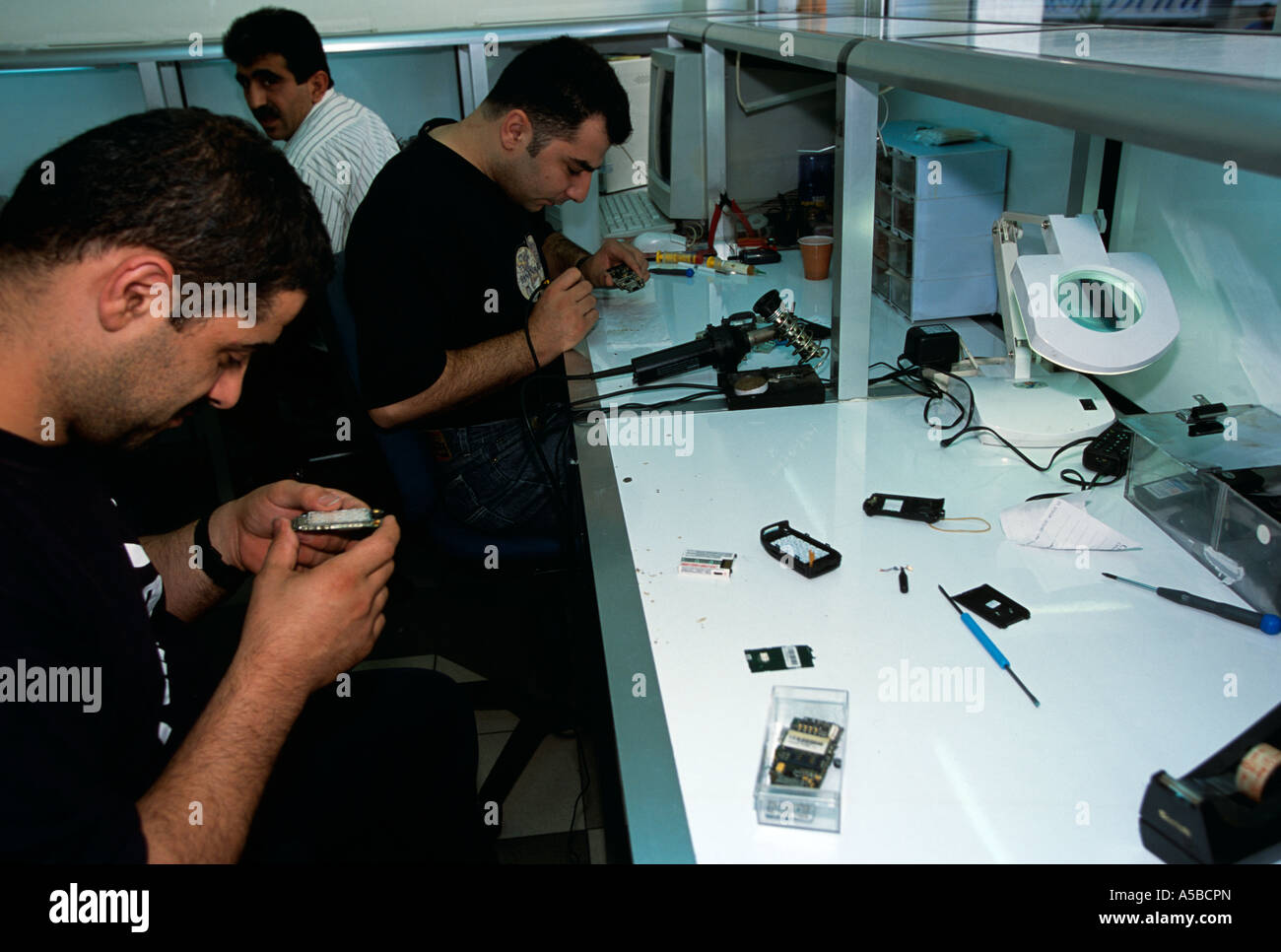 Men at work in a mobile phone repair shop Beirut Stock Photo - Alamy