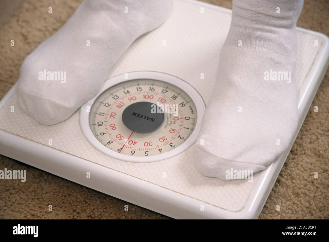underweight woman weighing herself on bathroom scales Stock Photo - Alamy