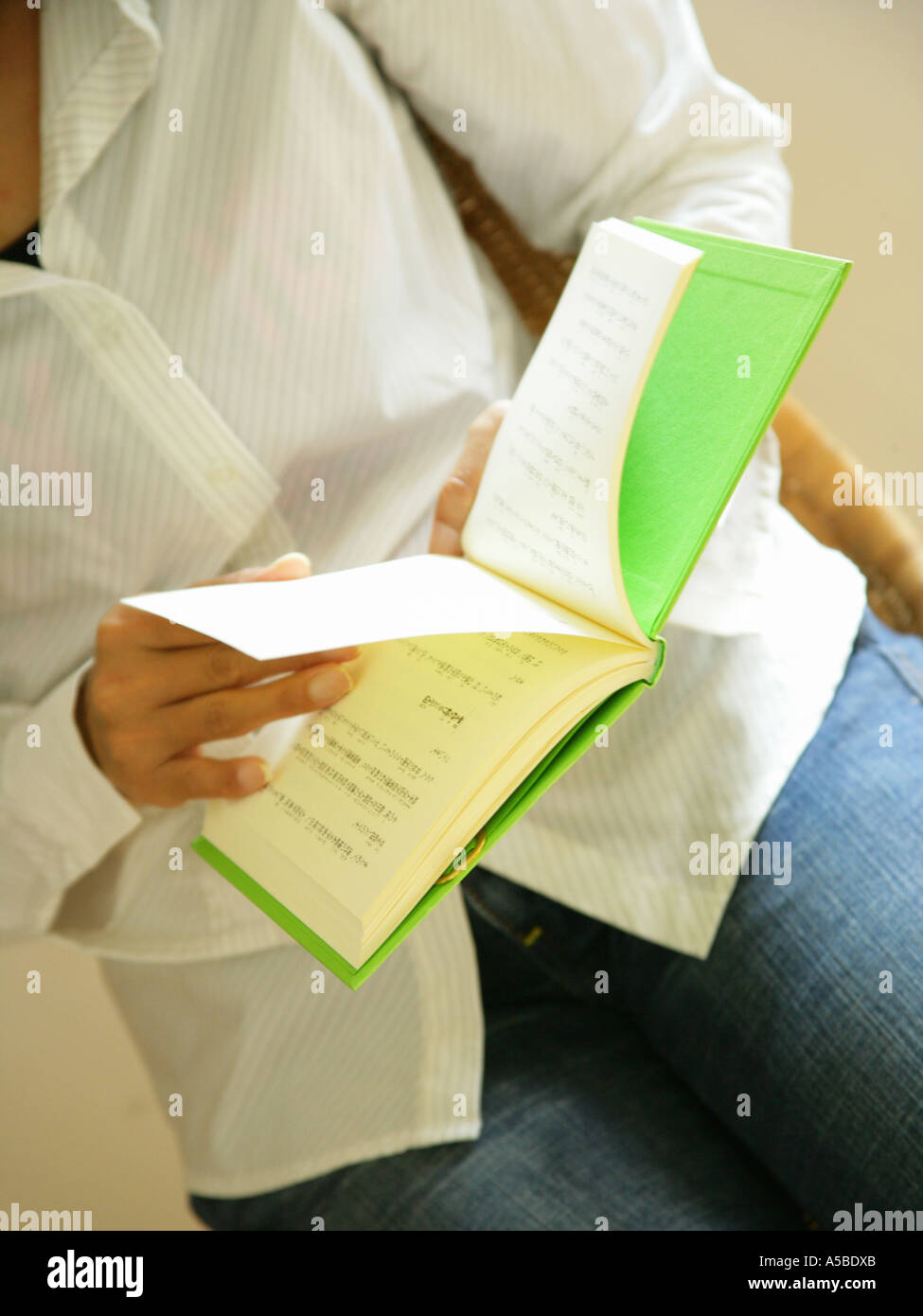 Mid section view of a mid adult woman reading a book Stock Photo - Alamy
