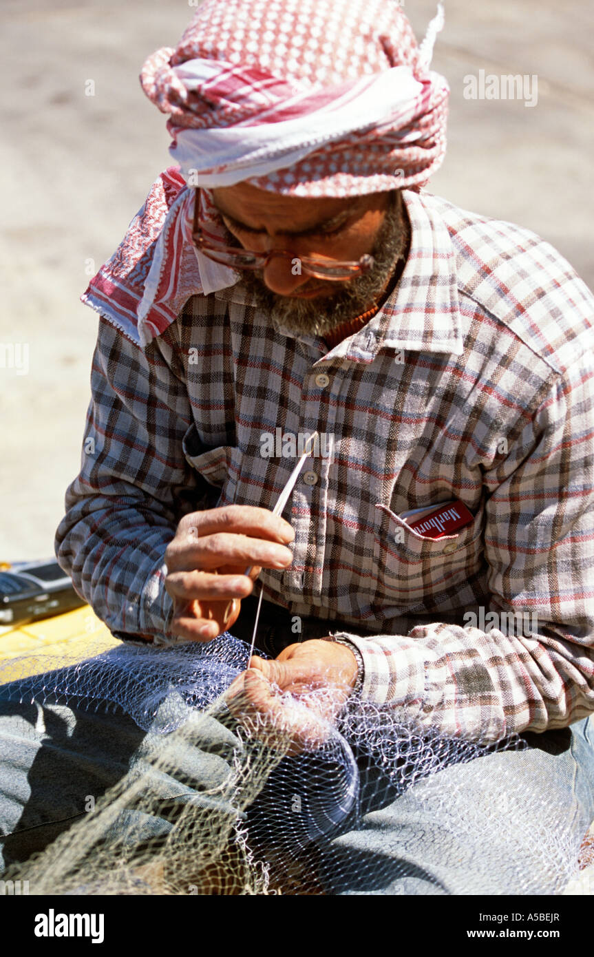 A fisherman fixing his net Stock Photo - Alamy