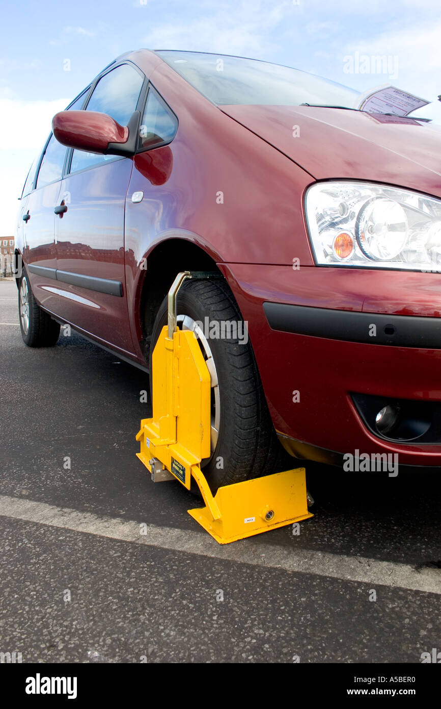 Car with wheel clamp on it Stock Photo - Alamy