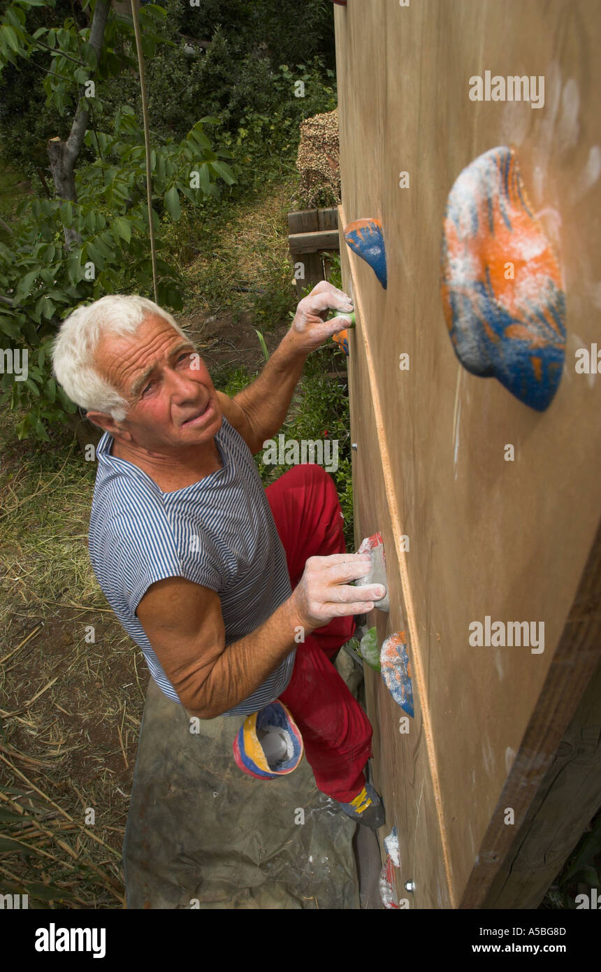 elderly man climbing on an artificial climbing wall view with climber ...