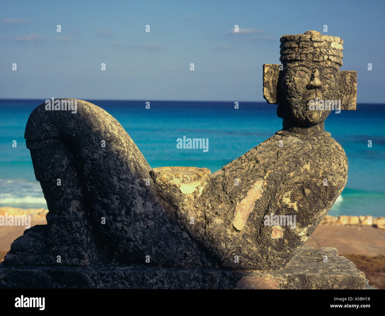 Mexico Carabbean coast Cancun sculpture of a Chac Mool with sea in bkgd ...
