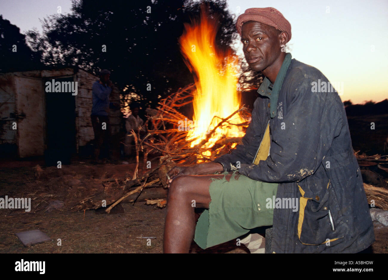A villager sitting next to a campfire, South Africa Stock Photo - Alamy
