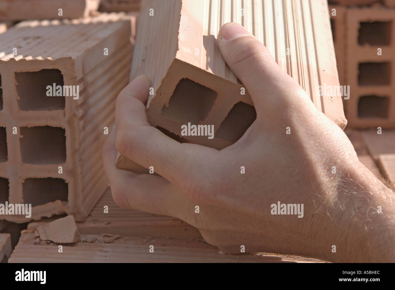 Hand picking up brick Stock Photo - Alamy