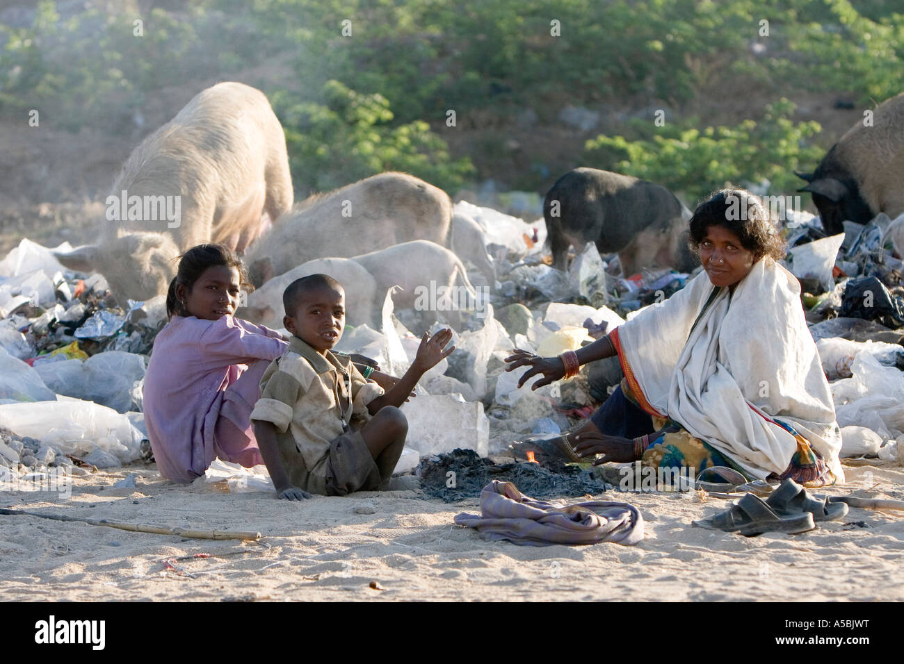 Poor Indian family keeping warm by a fire on the waste ground ...
