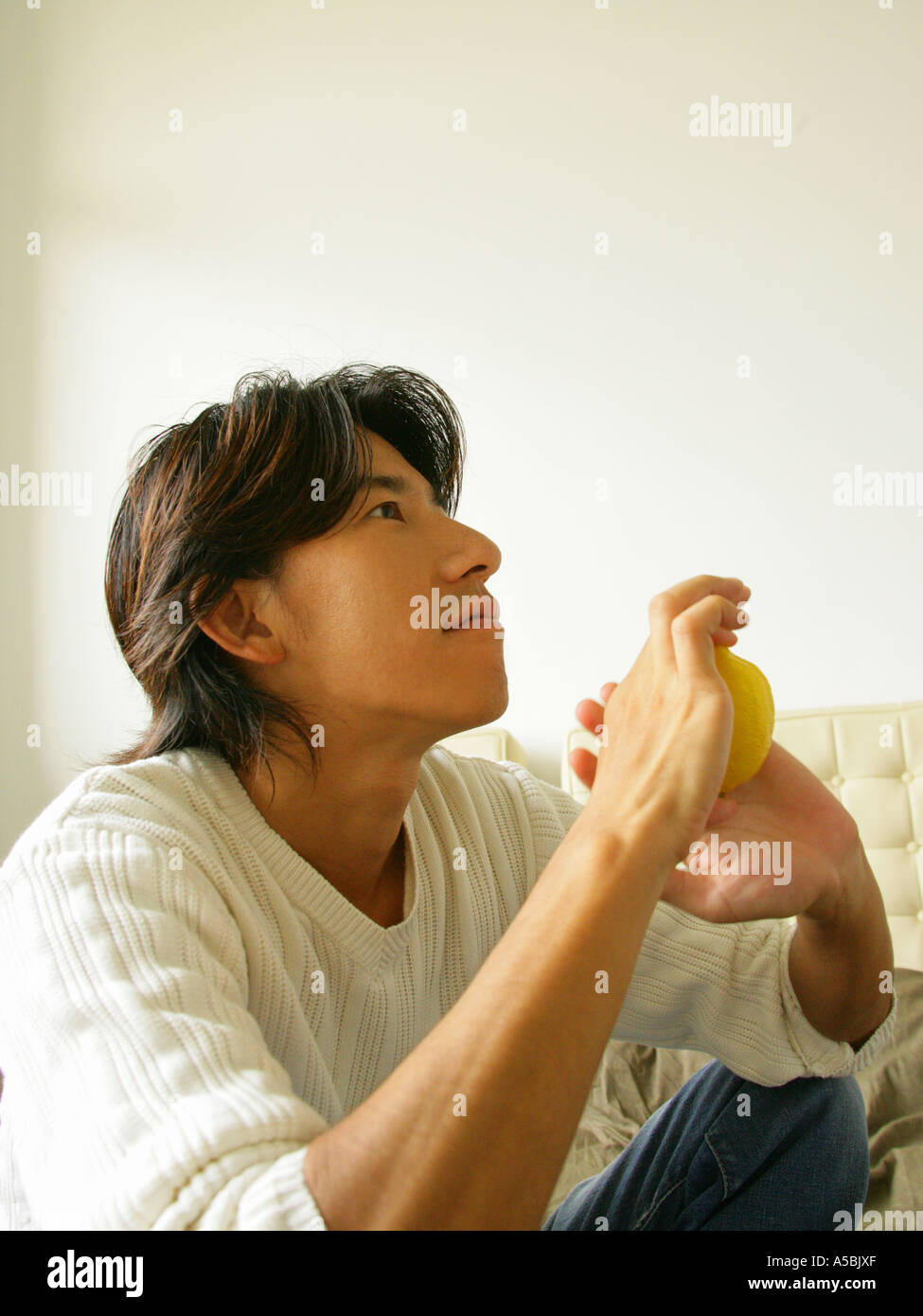 Young man holding a lemon Stock Photo - Alamy