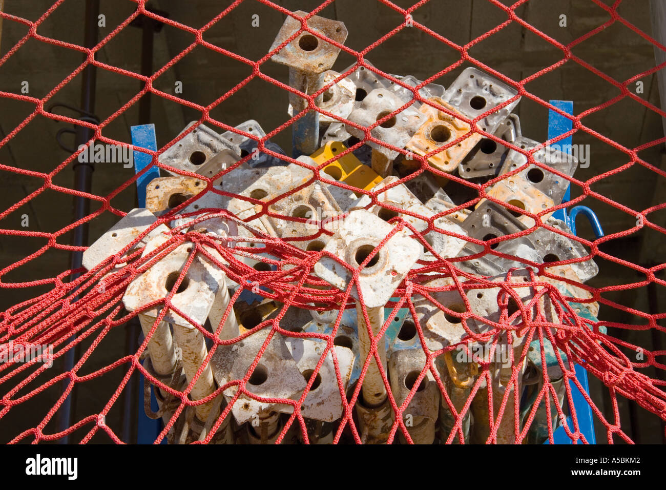 Scaffolding uprights behind safety net Stock Photo - Alamy