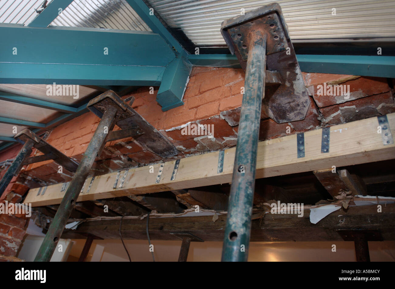 ACROW PROPS WITH STRONG BOYS HOLDING A SUPPORTING WALL BEFORE A RSJ IS ...