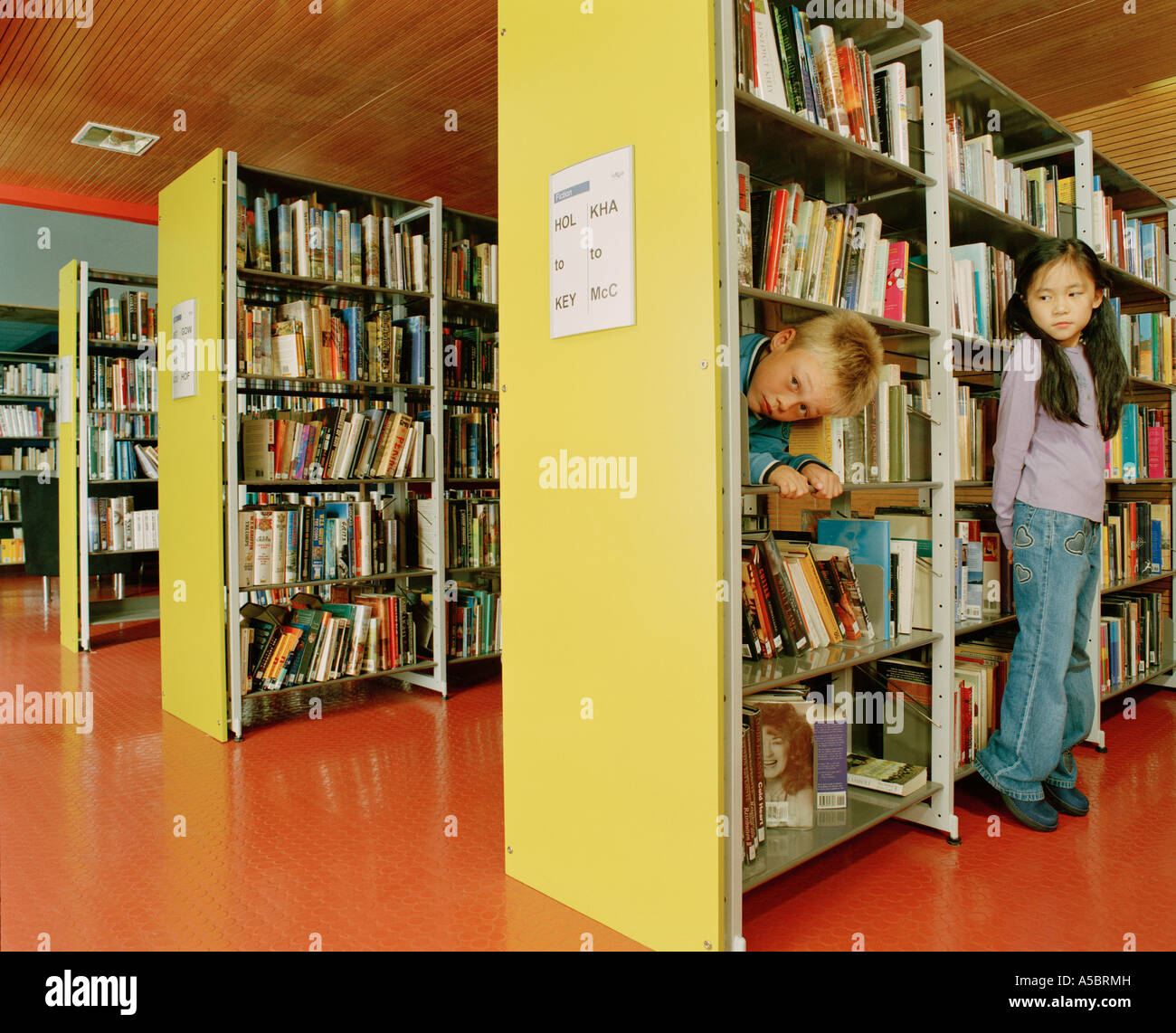 Children playing Hide and Seek in a library Stock Photo - Alamy