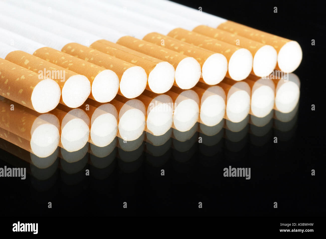 Cigarettes in a row on a mirror - black background Stock Photo - Alamy