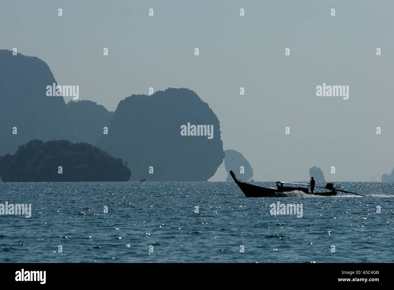 Traditional ail boat silhouette against blue karst cliff background off ...