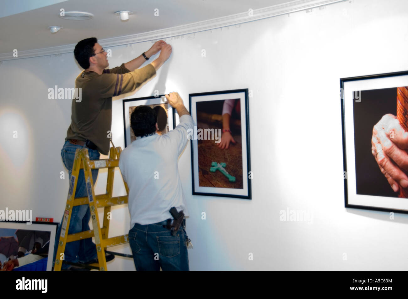 Hanging photographs in a photo Exhibition A matter of Faith by Danny ...