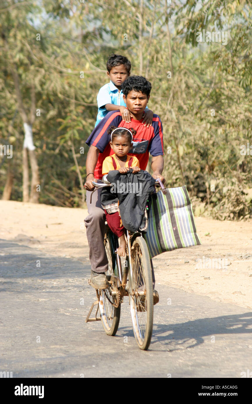 Three children on a bike in Orissa India Stock Photo - Alamy