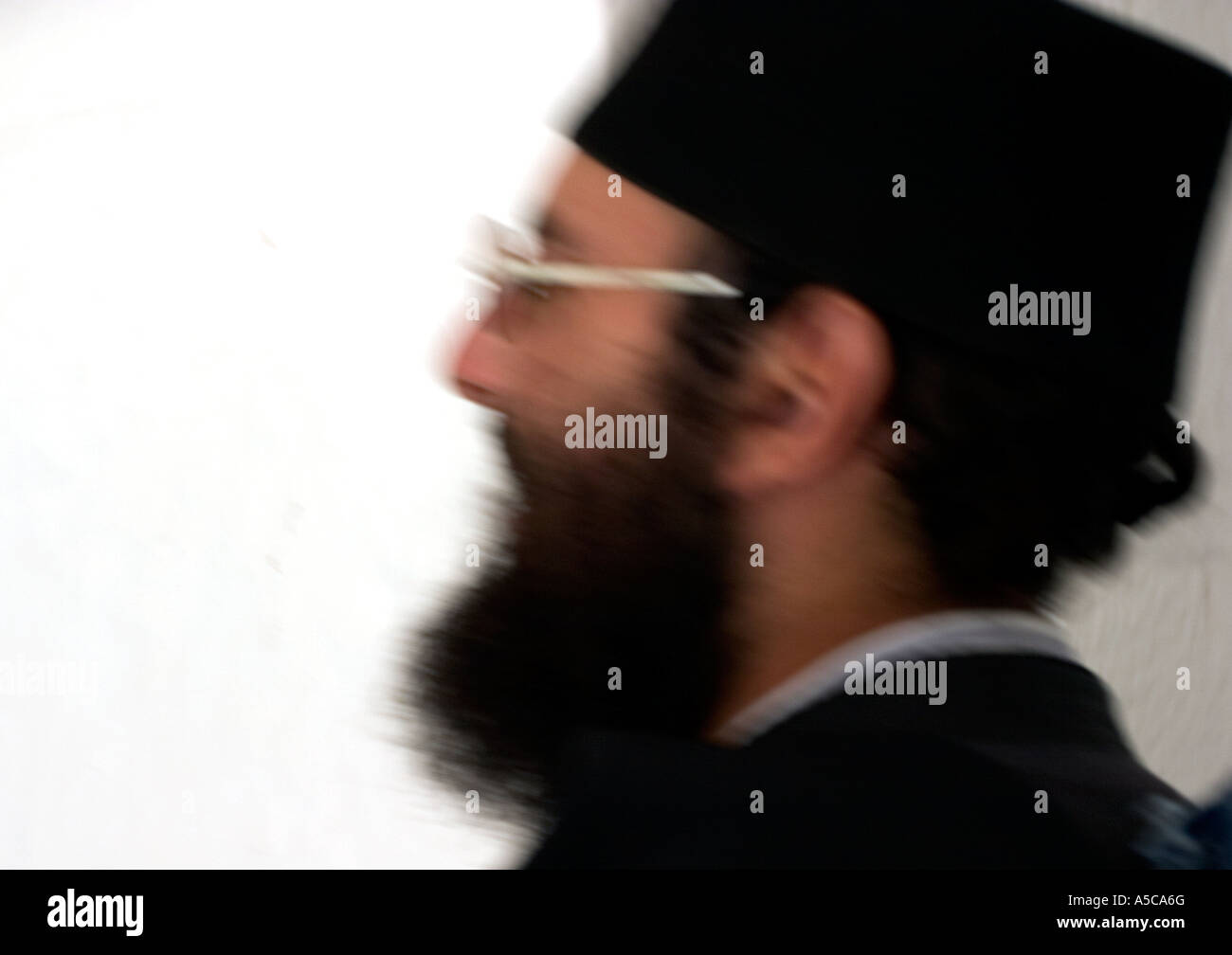 Portrait of black dressed Greek Orthodox clergyman wearing hat beard ...