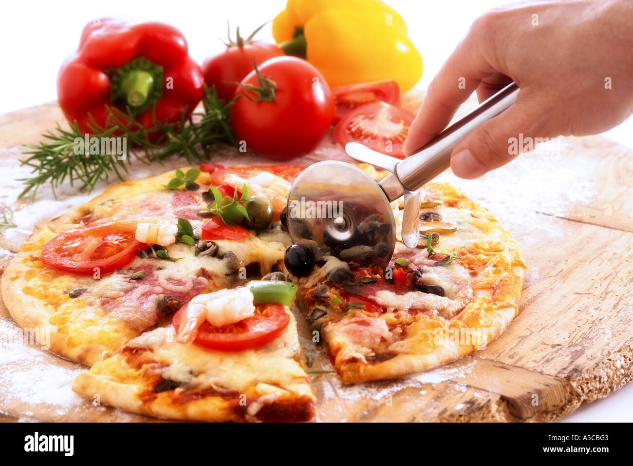 Man slicing pizza with wheel cutter Stock Photo - Alamy