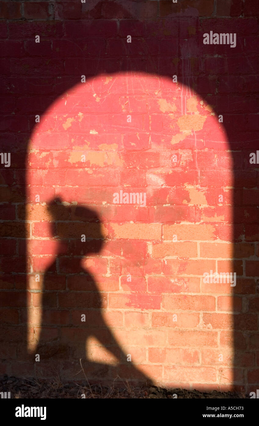 A color vertical image of the shadow of a woman sitting calmly in an ...