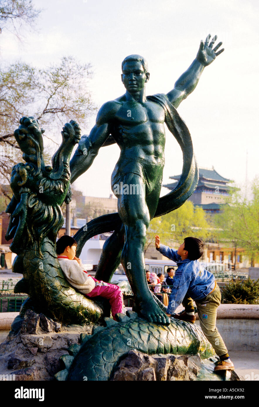 Harbin Heilongjiang China Children playing on statue of man subduing ...