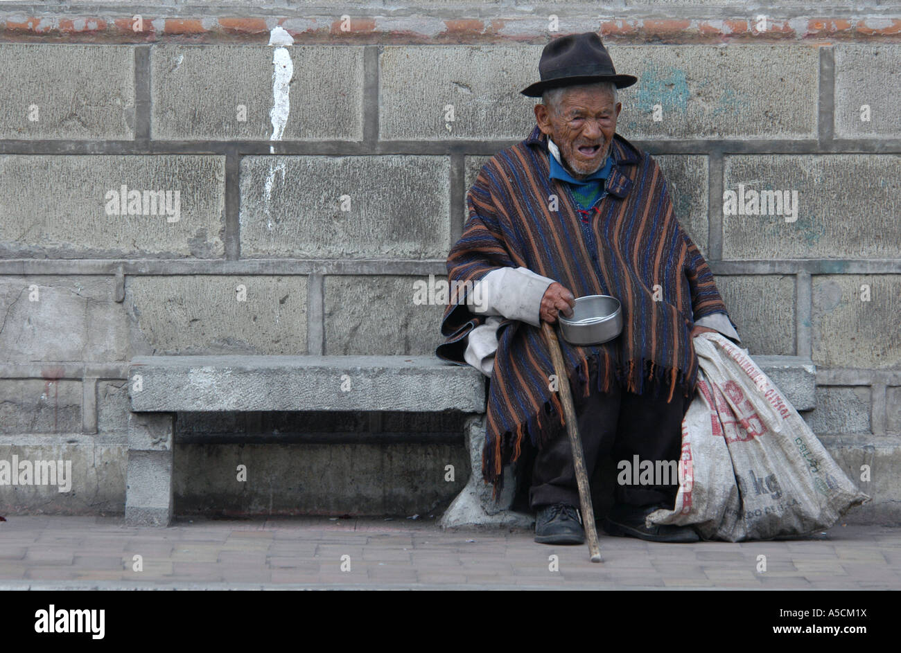 Old Ecuadorian man in a traditional Andean poncho and hat sitting in ...