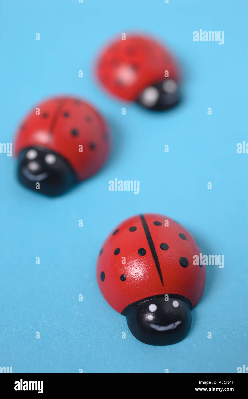 Three wooden ladybugs on blue Stock Photo - Alamy