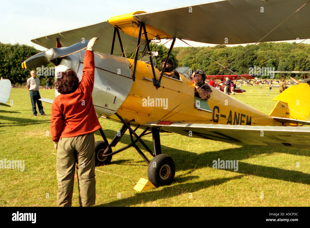 Starting the engine of a De Havilland Tiger Moth biplane Stock Photo ...