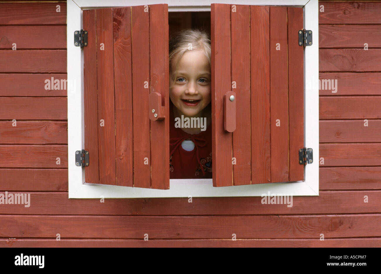 Girl (6-7) looking through window, smiling Stock Photo - Alamy