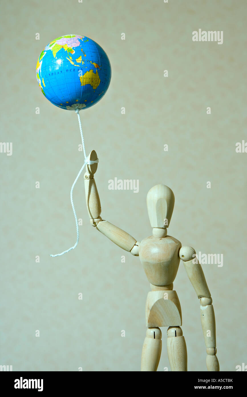 Wooden artist’s manikin holds globe on a string Stock Photo - Alamy