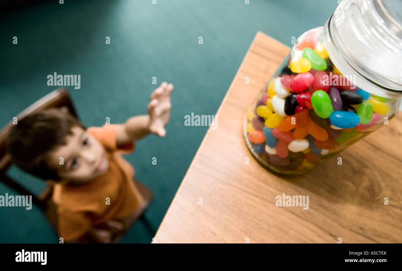 Looking down on boy reaching for sweet jar Stock Photo - Alamy