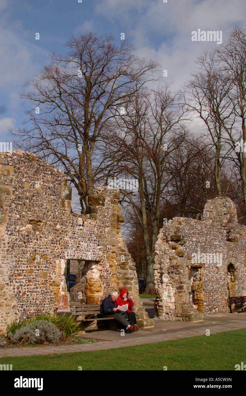 Elderly Couple reading newspaper in front of the wall of the ...