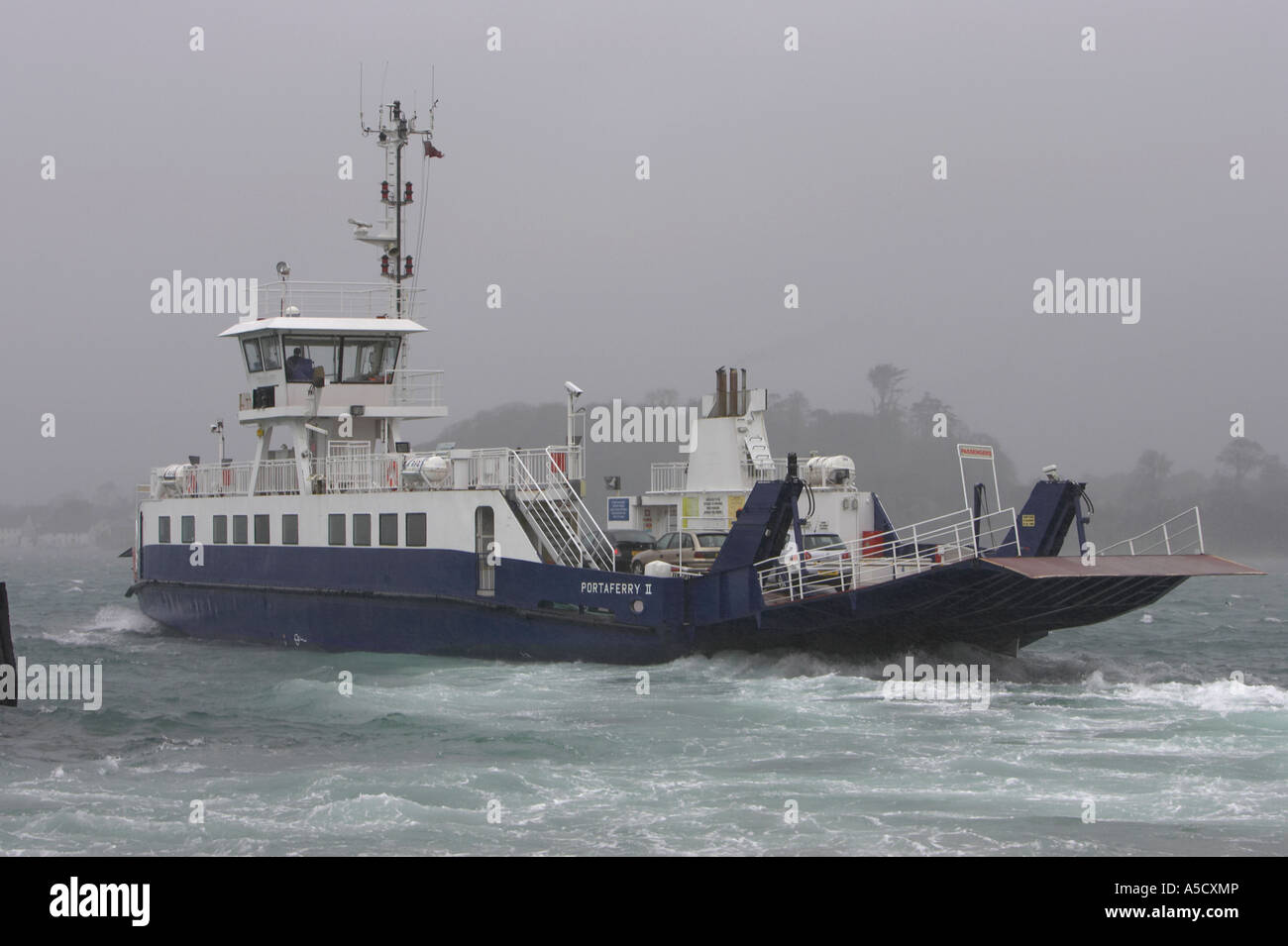 portaferry ferry making its way out past the pier in rough seas and ...