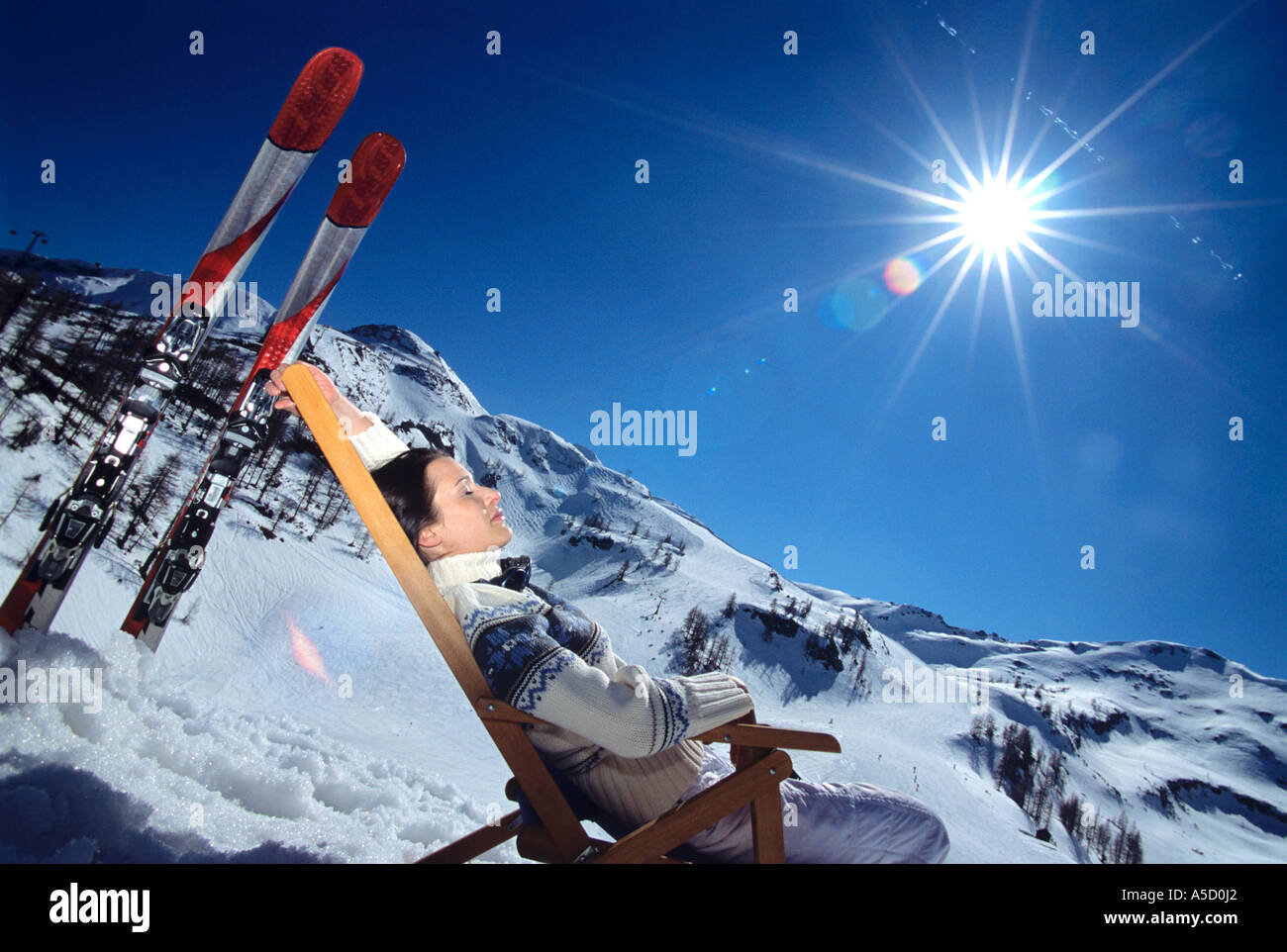 Woman relaxing on deckchair in alps, side view Stock Photo - Alamy