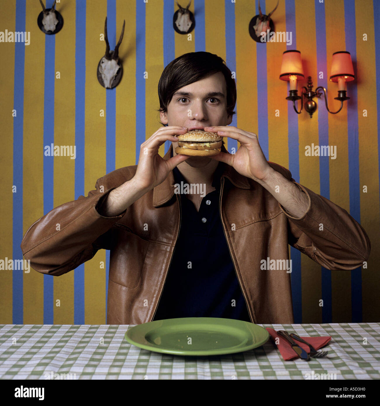 Young man eating burger, portrait Stock Photo - Alamy